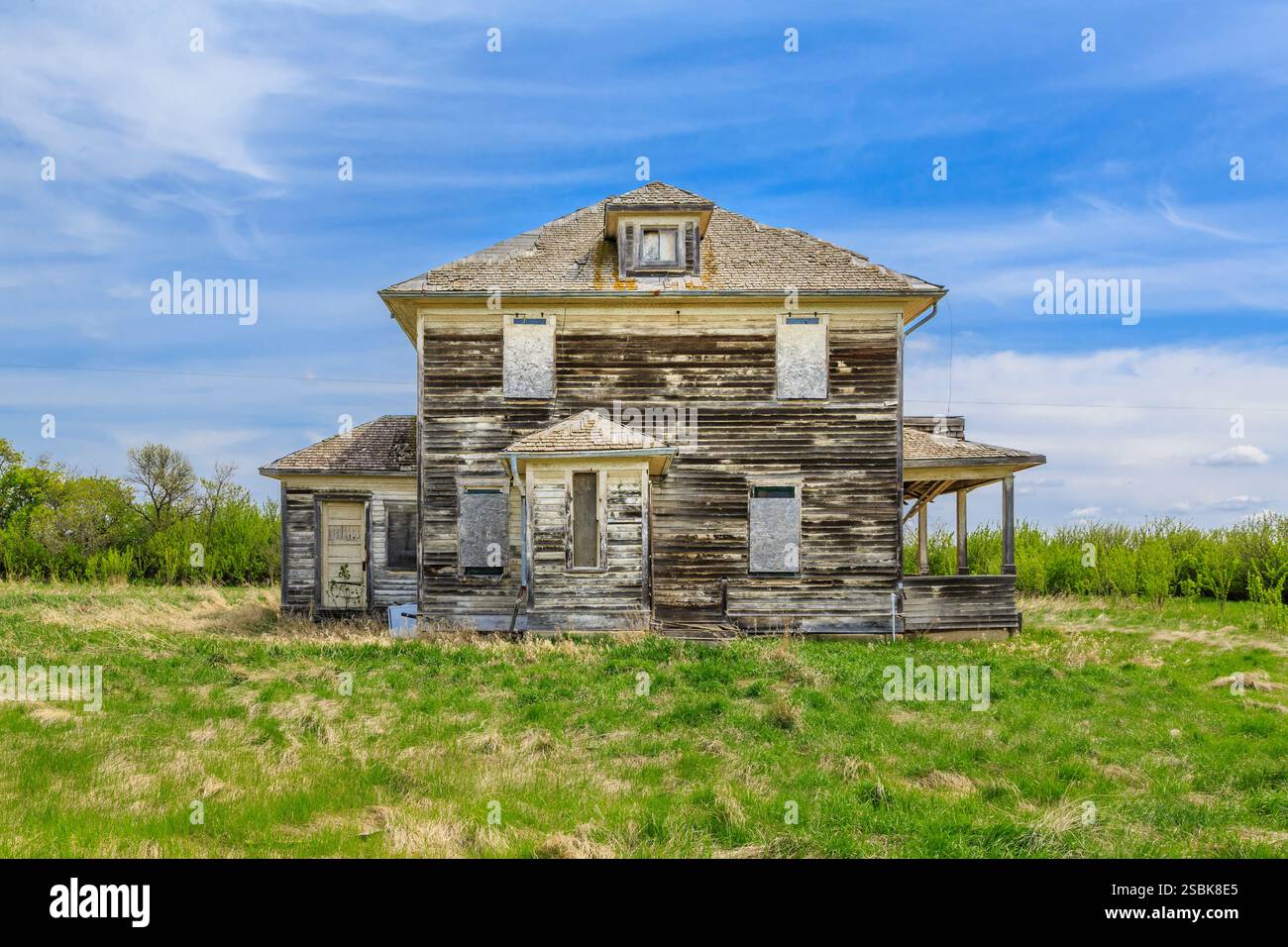 Large, old house with a slanted roof. The house is surrounded by a ...