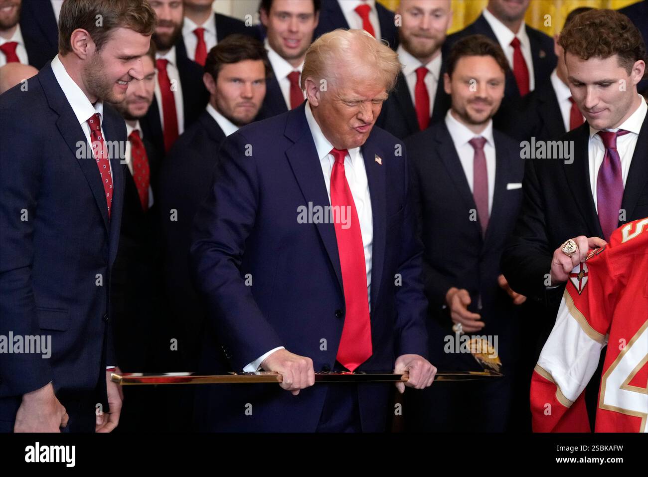 President Donald Trump holds a hockey stick before he poses for a photo ...