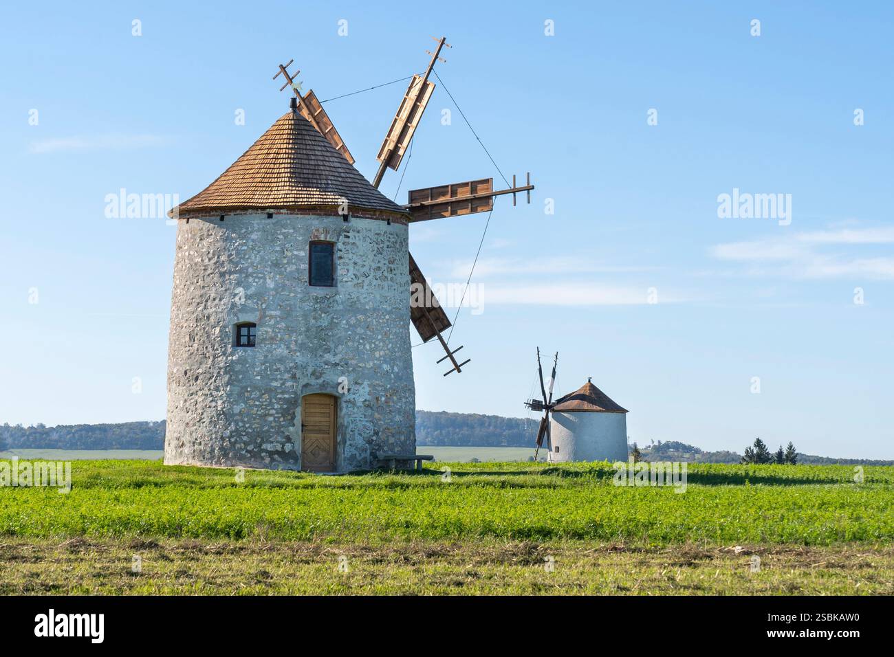 Rustic stone windmills in a grassy field Stock Photo - Alamy