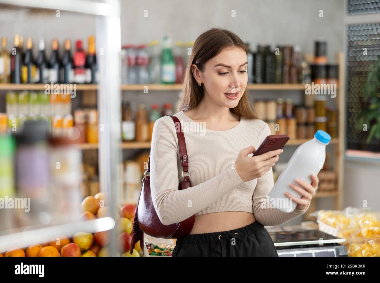 Young woman scanning qr code of milk Stock Photo - Alamy