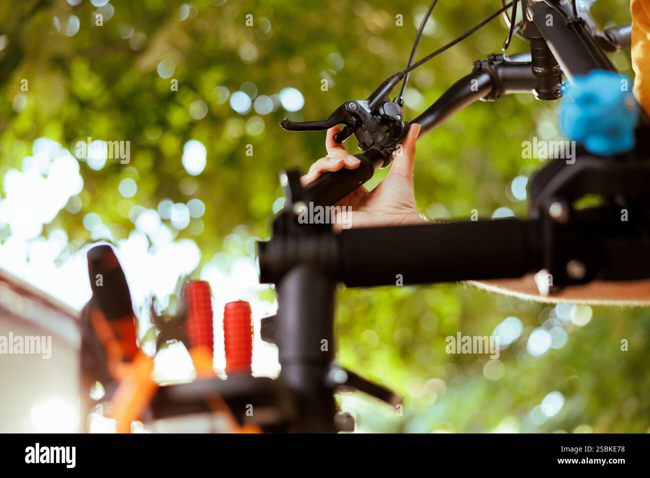 Close-up of person using expert work tools to adjust and secure bike ...
