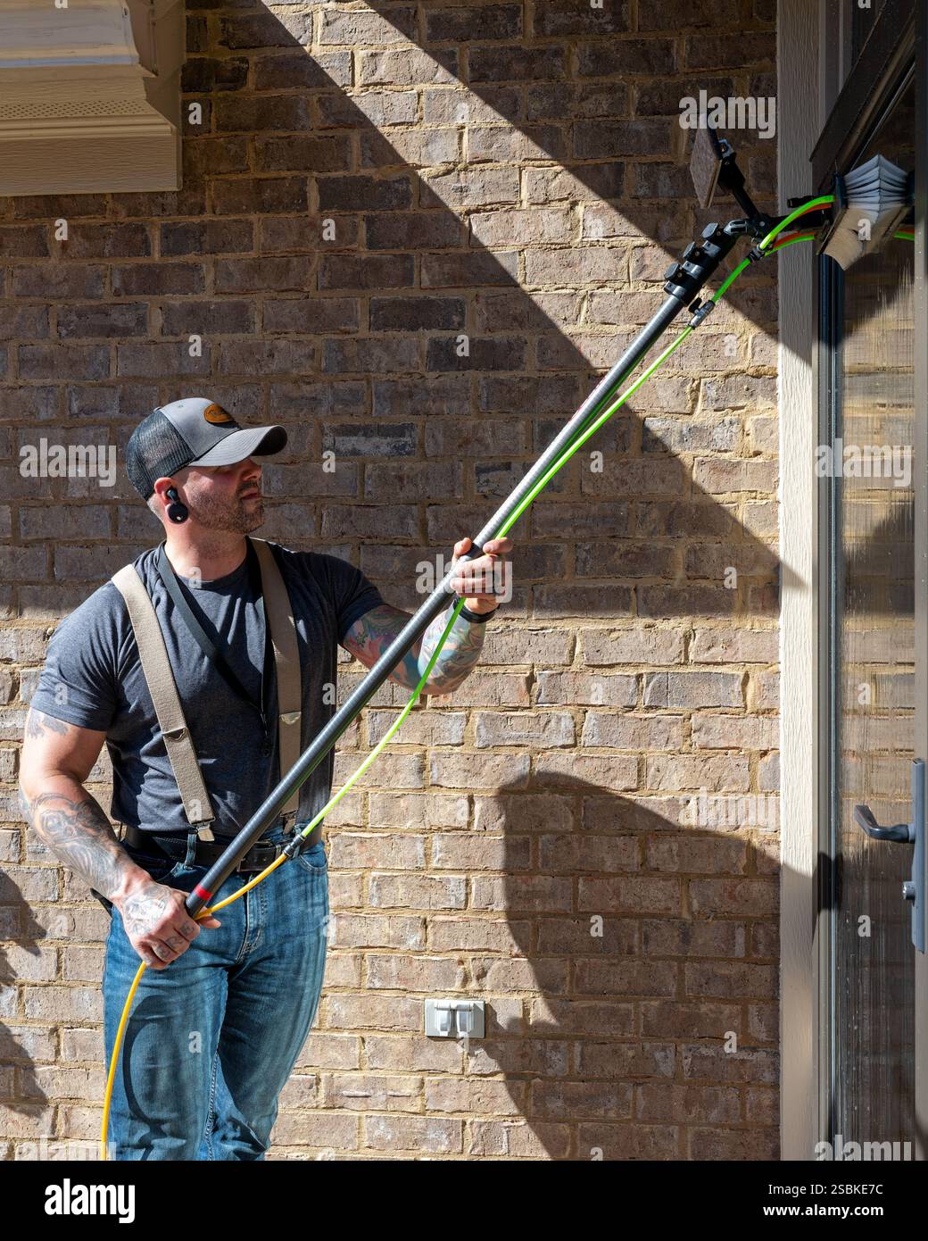 Male adult window washer employee or worker washing windows on a ...