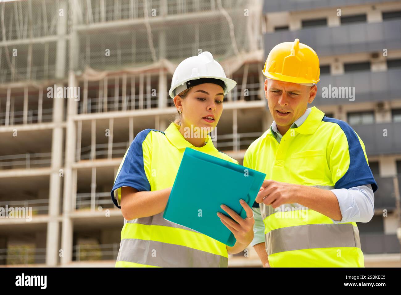 Two builders planning their work in construction plant Stock Photo - Alamy