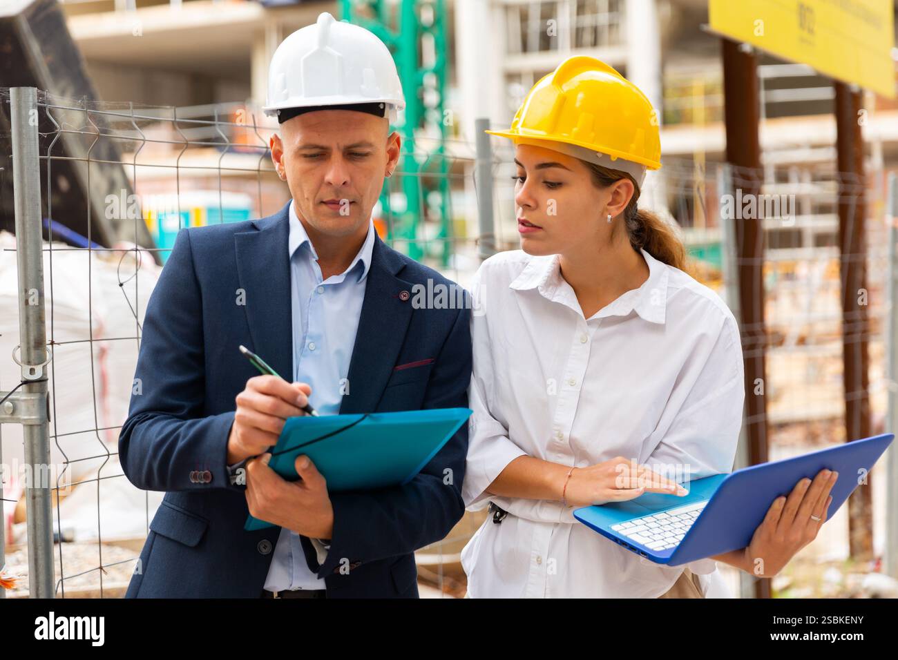 Two architects with laptop discussing construction plan Stock Photo - Alamy