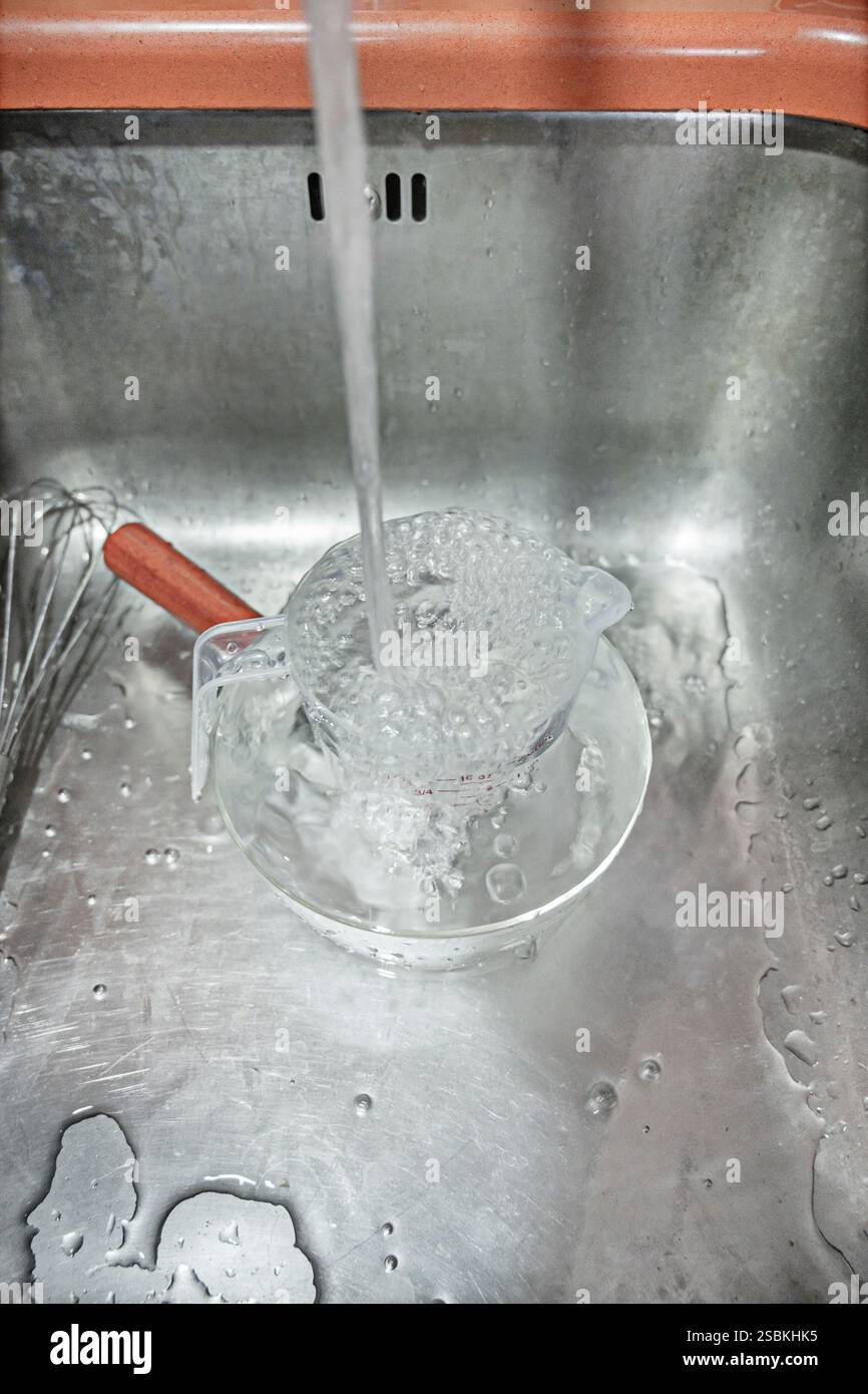 A good stream of hot water falling from the tap onto some containers ...