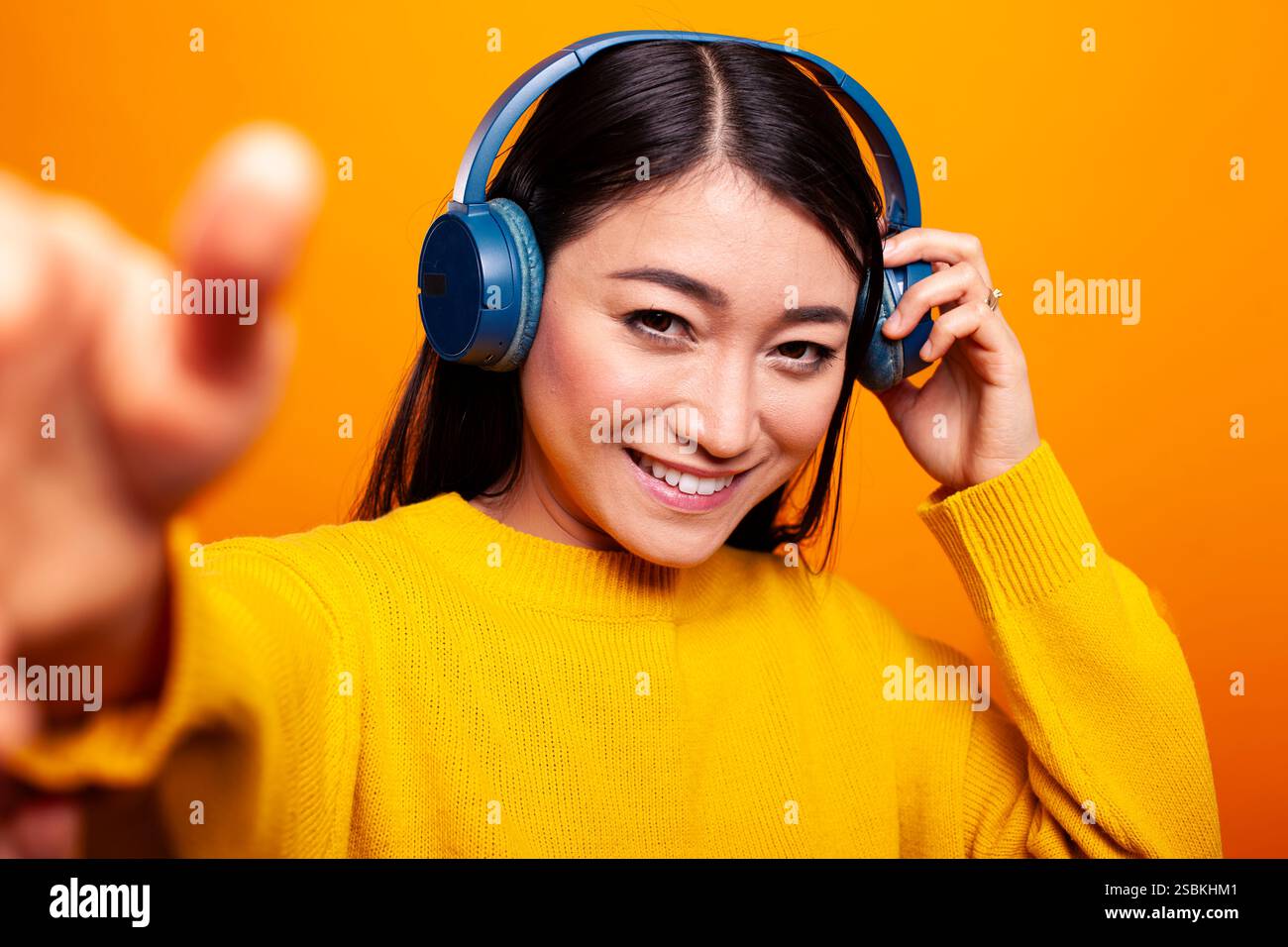 Smiling woman holding the camera and recording a video, showing enthusiasm and engagement ...