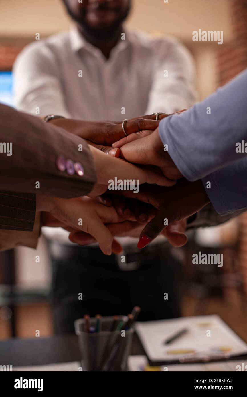 Multiethnic employees stack hands in startup office, representing ...
