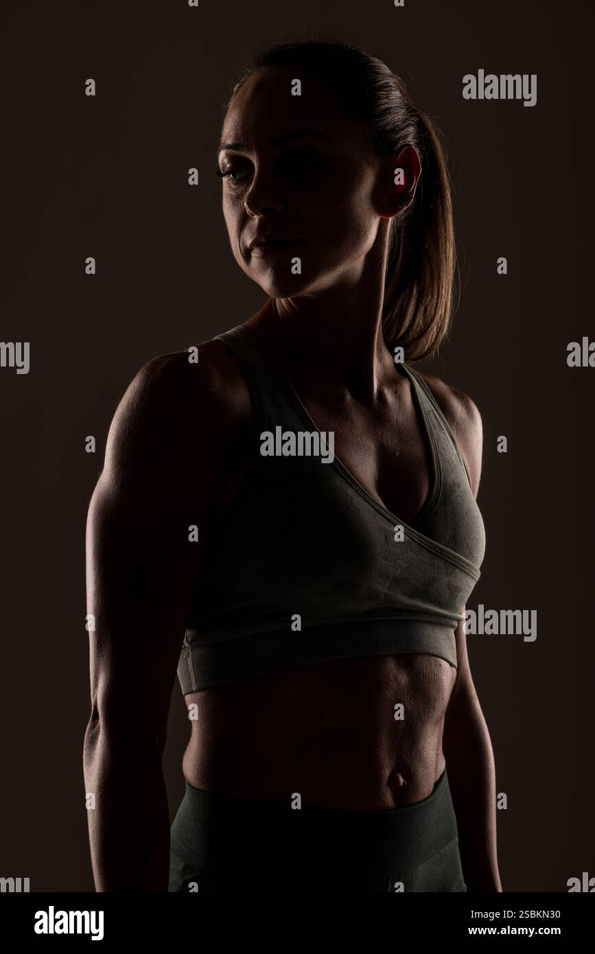 Silhouette of a strong and confident woman in athletic attire, with an ...