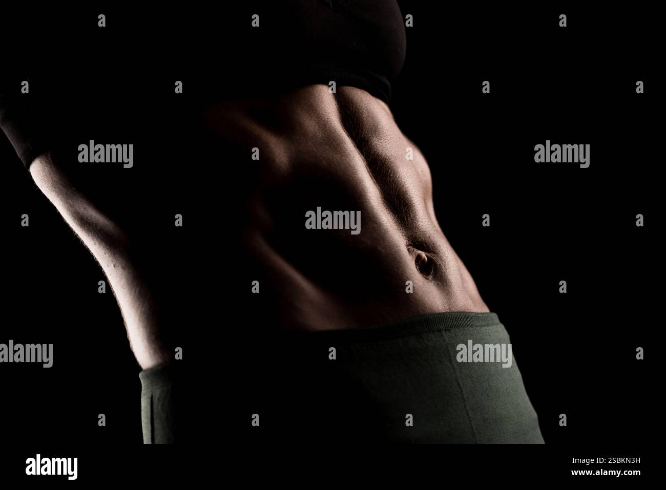 Detailed focus on a well-defined, muscular abdomen emphasizing physical ...