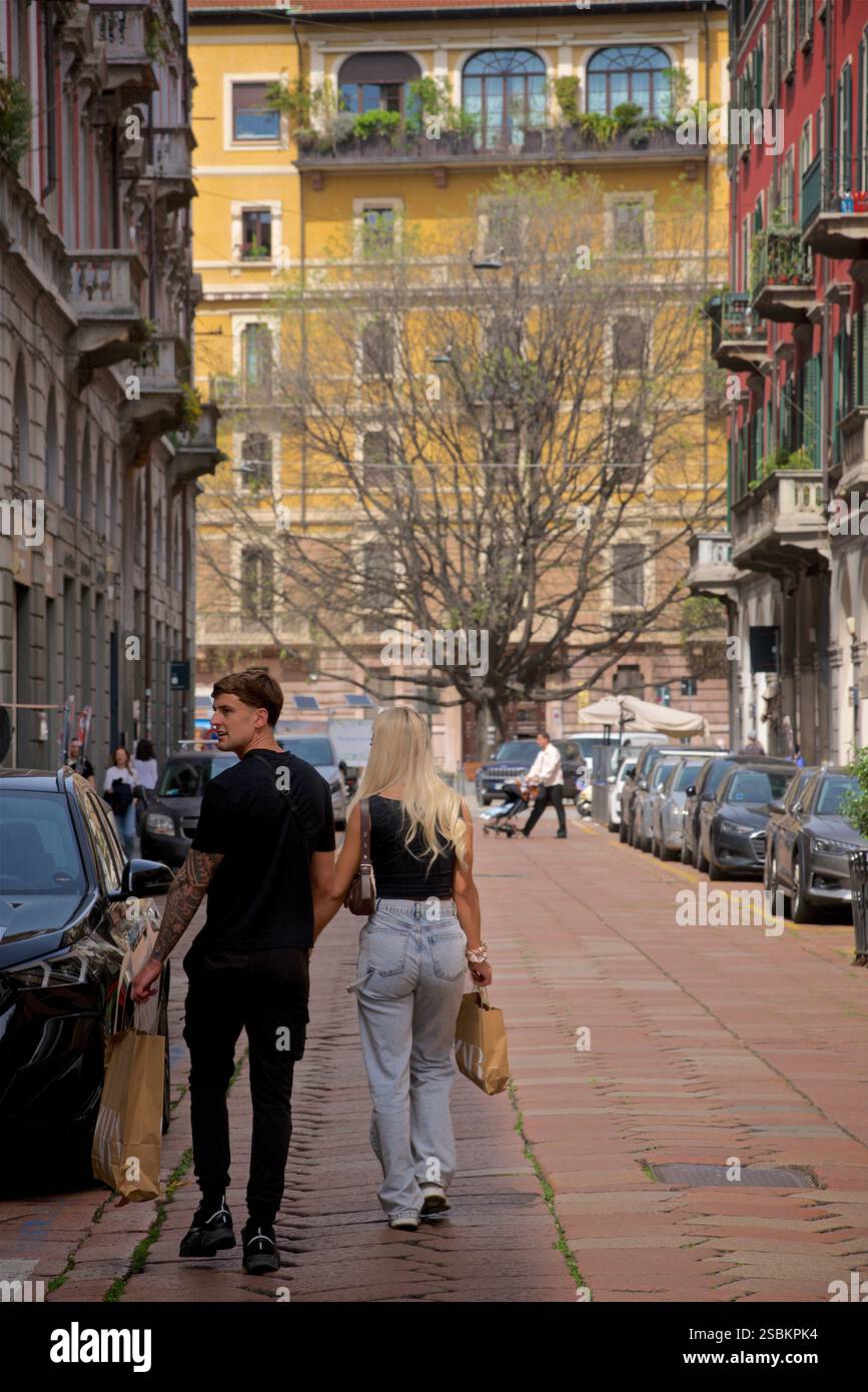 Typical Milanese street scene, central Milan. Couple walking together ...