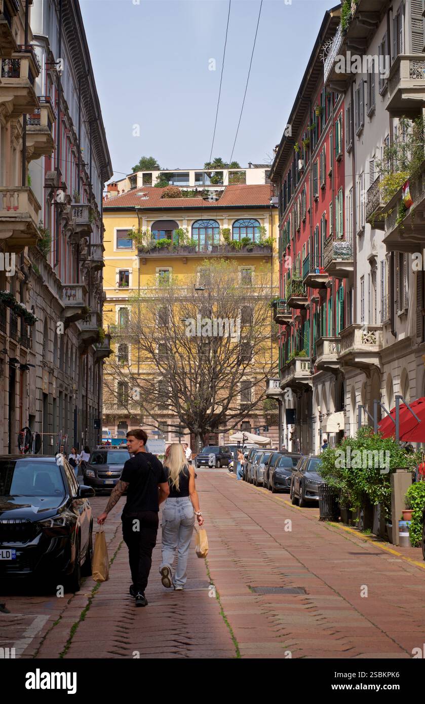 Typical Milanese street scene, central Milan. Couple walking together ...