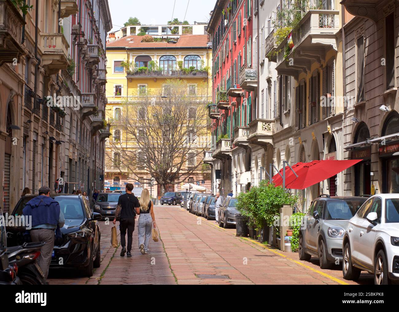 Typical Milanese street scene, central Milan. Couple walking together ...