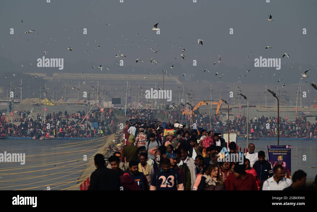 PRAYAGRAJ, INDIA - JANUARY 29: Devotees walk over the pontoon bridge ...