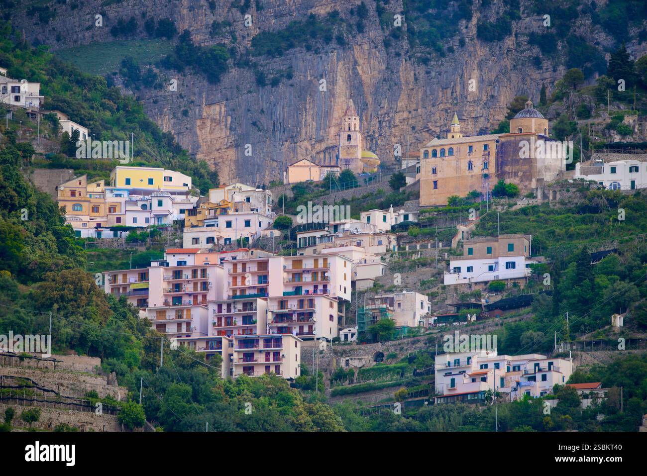 Buildings and churches hug the hillside above and along the coast from ...