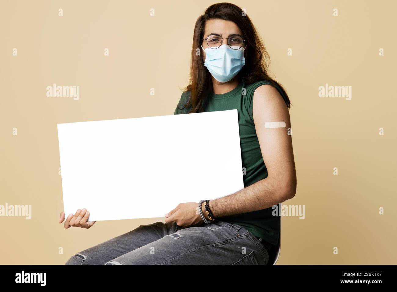 Middle-eastern guy in face mask holding board Vaccination Saves Lives ...