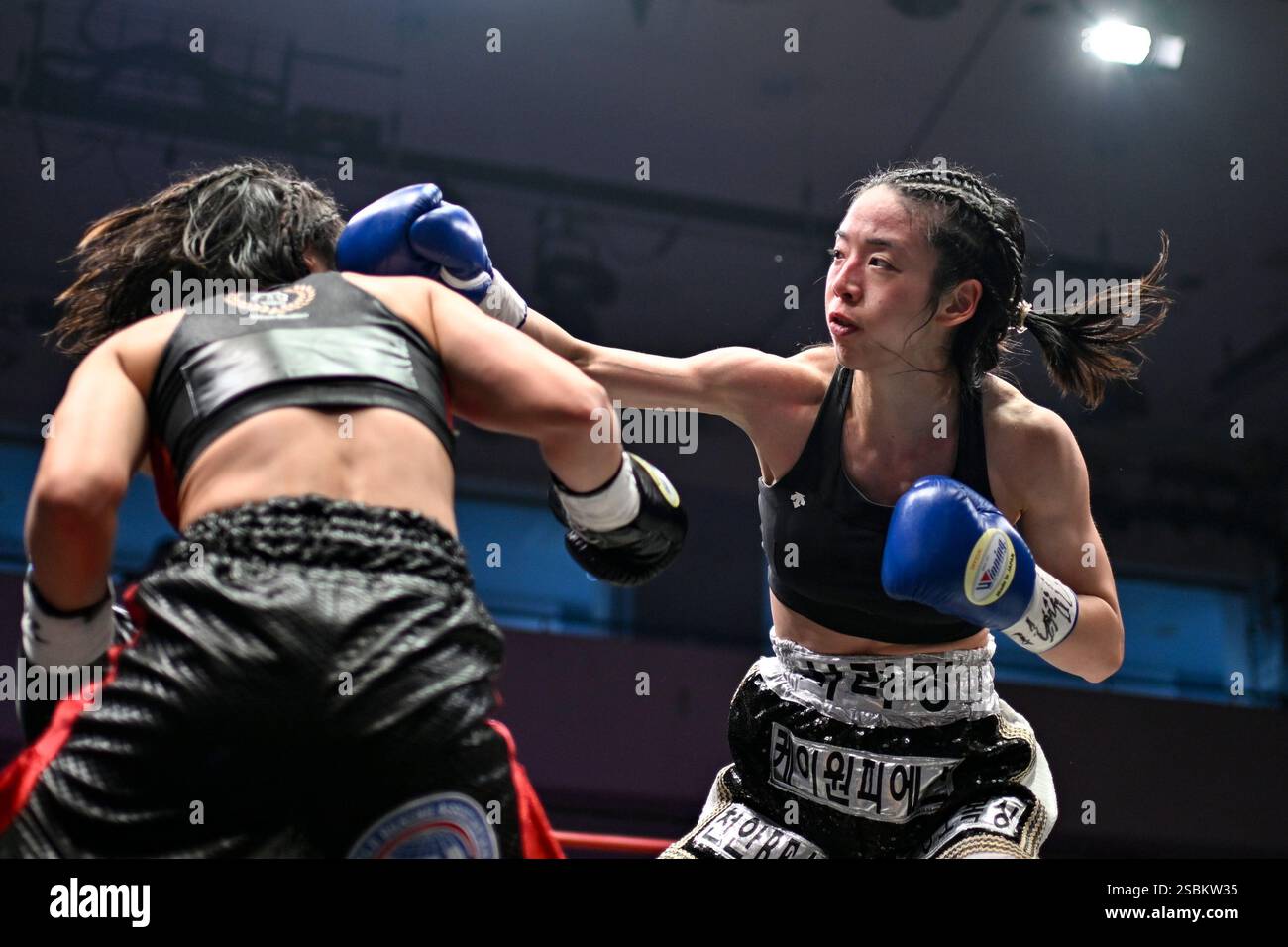 South Korea's Seo Ye-Kyeng (blue gloves) throws a right at Japan's Yuko Kuroki (black gloves) in ...
