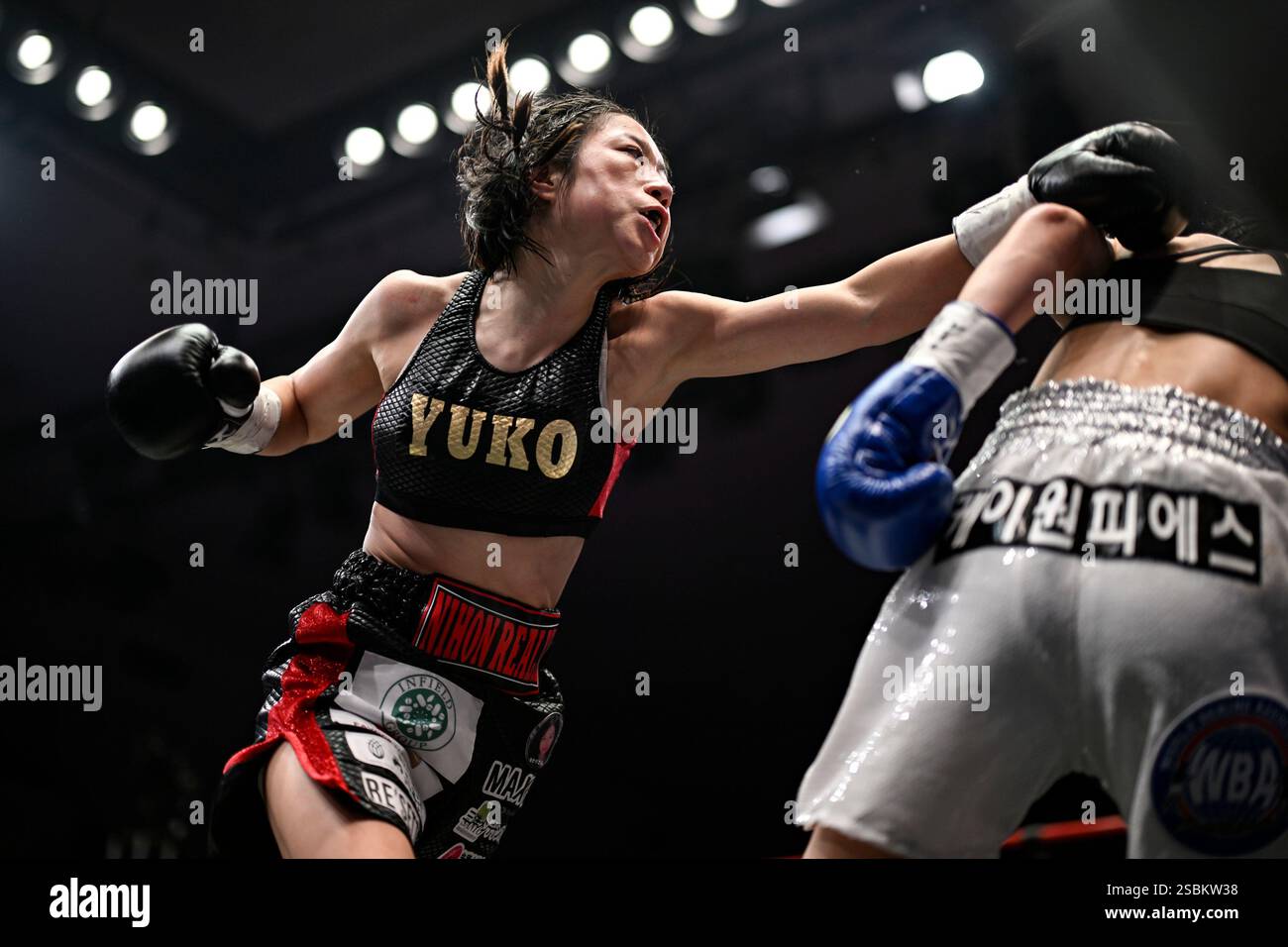 Japan's Yuko Kuroki (black gloves) throws a left at South Korea's Seo Ye-Kyeng (blue gloves) in ...