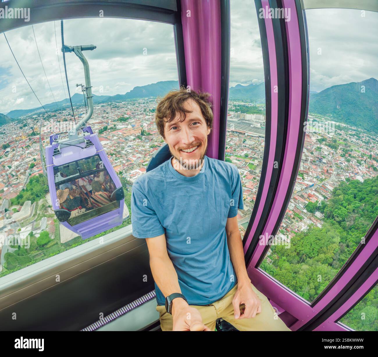 Male tourist riding a cable car in Orizaba, Mexico. Scenic aerial ...