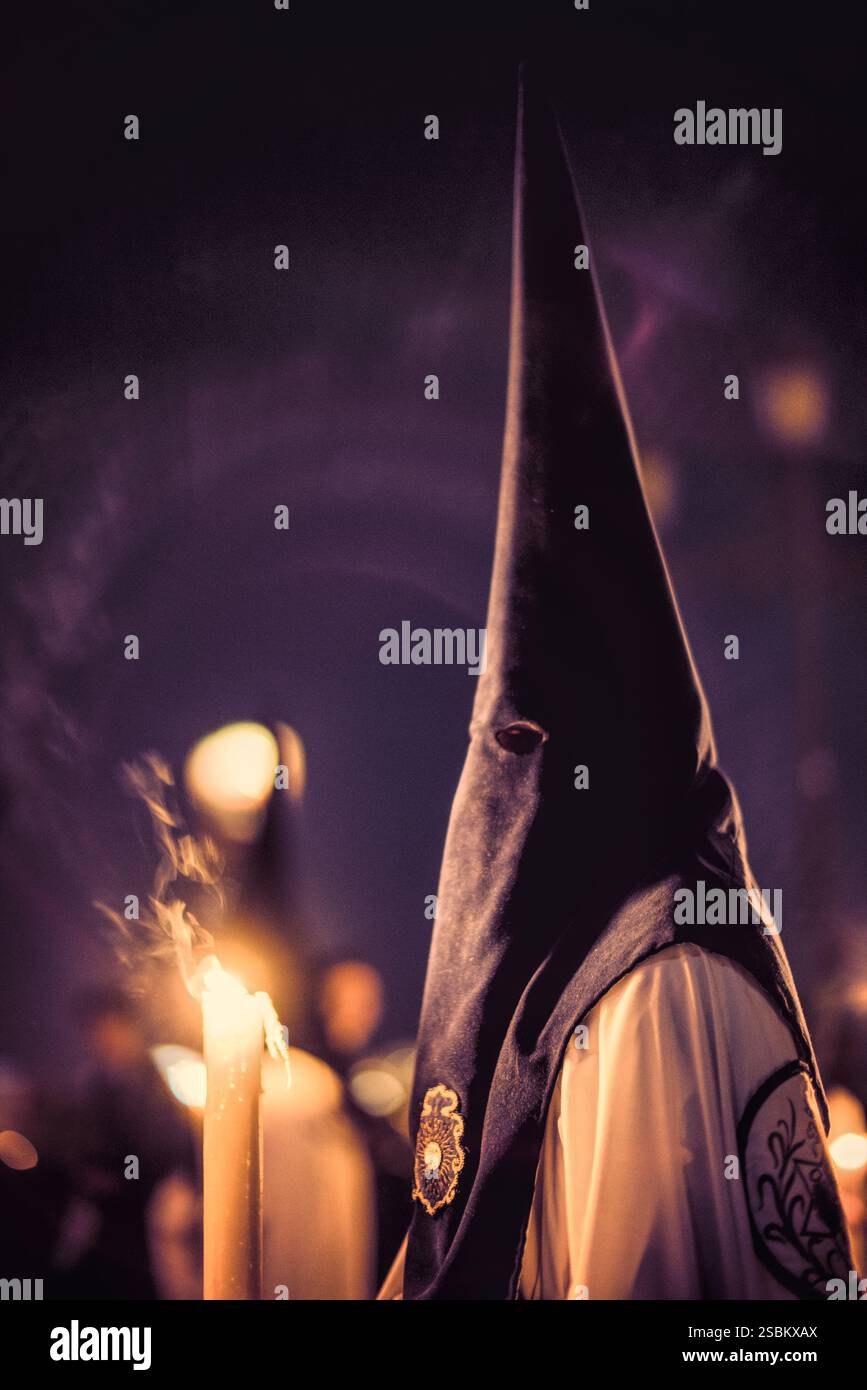 A nighttime procession featuring penitents with traditional outfits ...