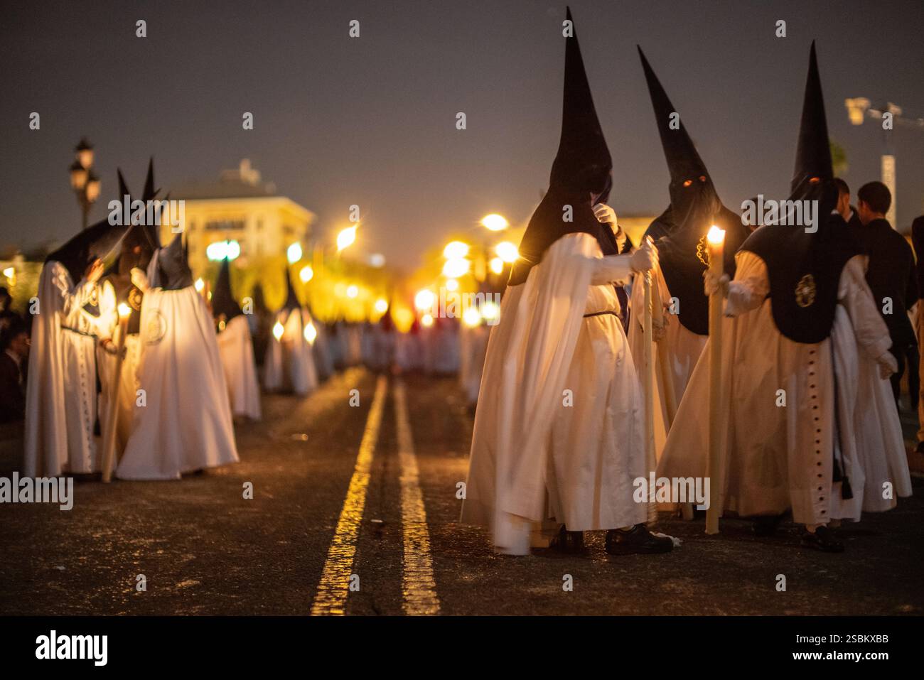 Nazarenos from the Estrella brotherhood walk with candles in the night ...