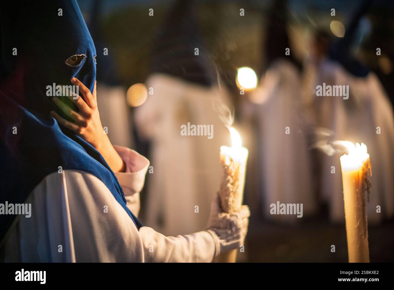 A nighttime procession featuring penitents with traditional outfits ...