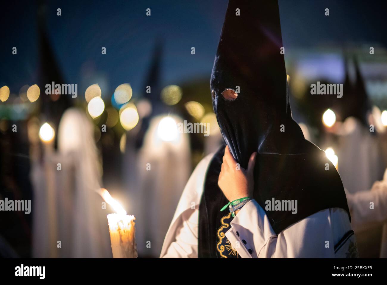 A nighttime procession featuring penitents with traditional outfits ...