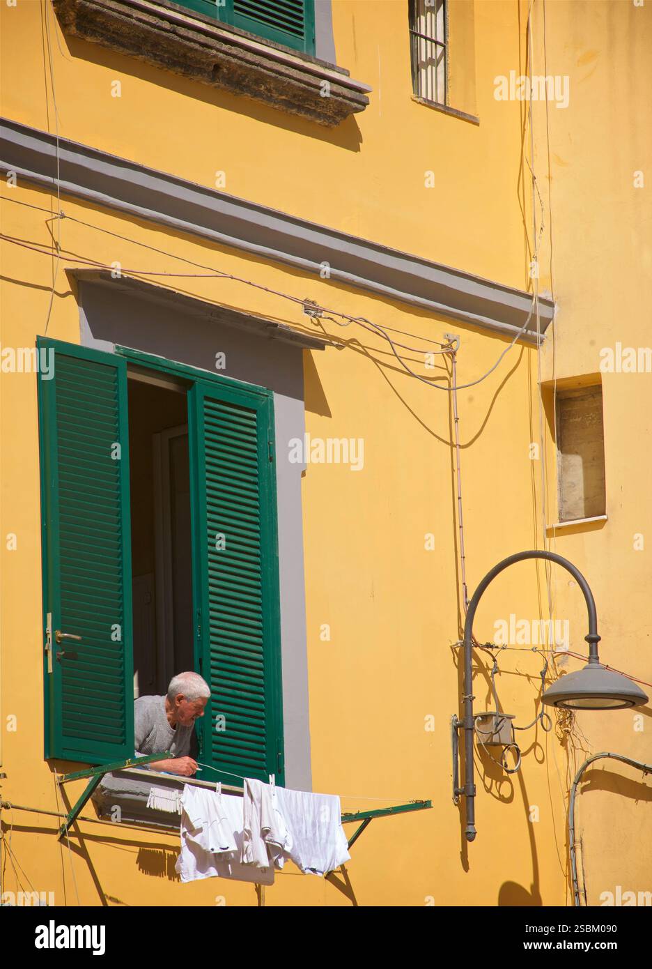 A typical Neapolitan street scene... Man looking our from a window in ...
