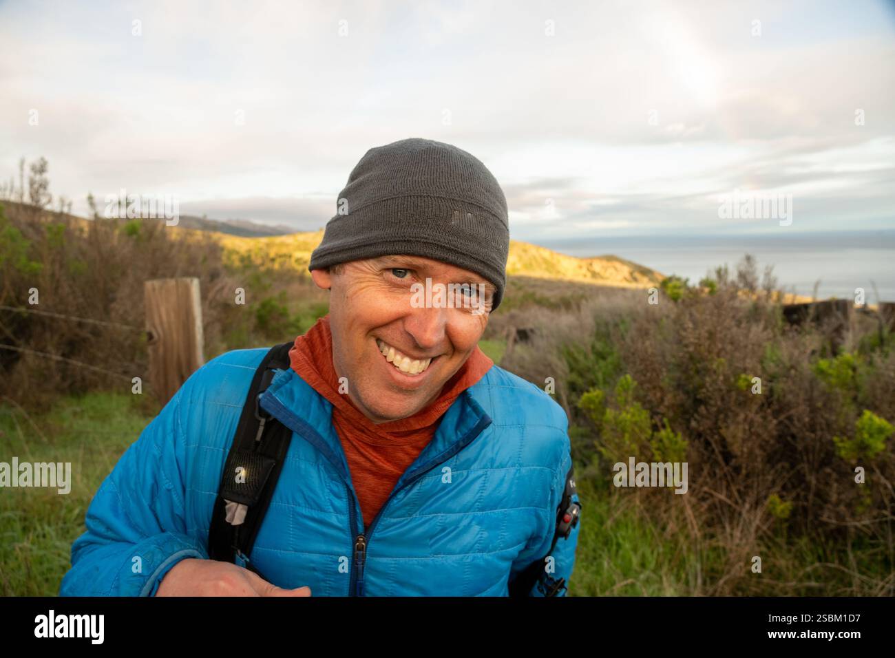 HIker Looks At Camera While Pausing To Take Off Backpack while hiking ...