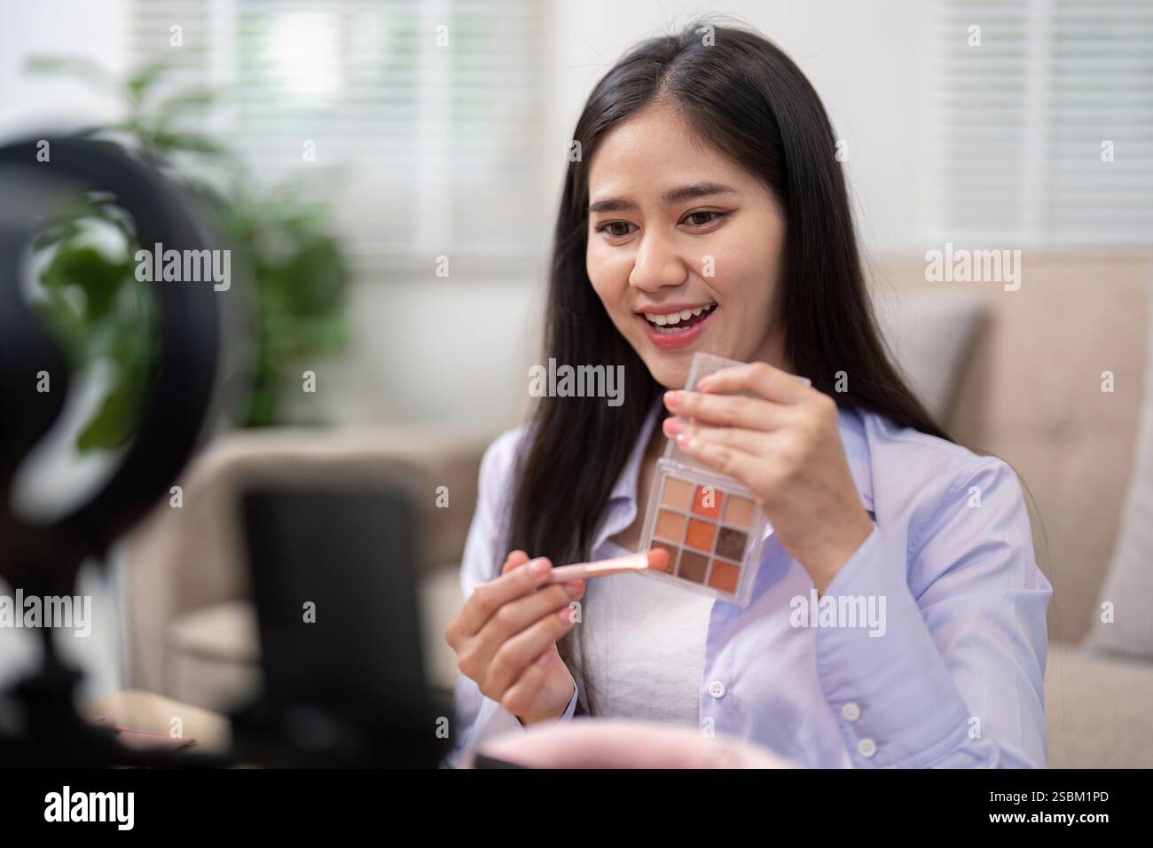 Beauty broker showcasing an eyeshadow palette during a live broadcast ...