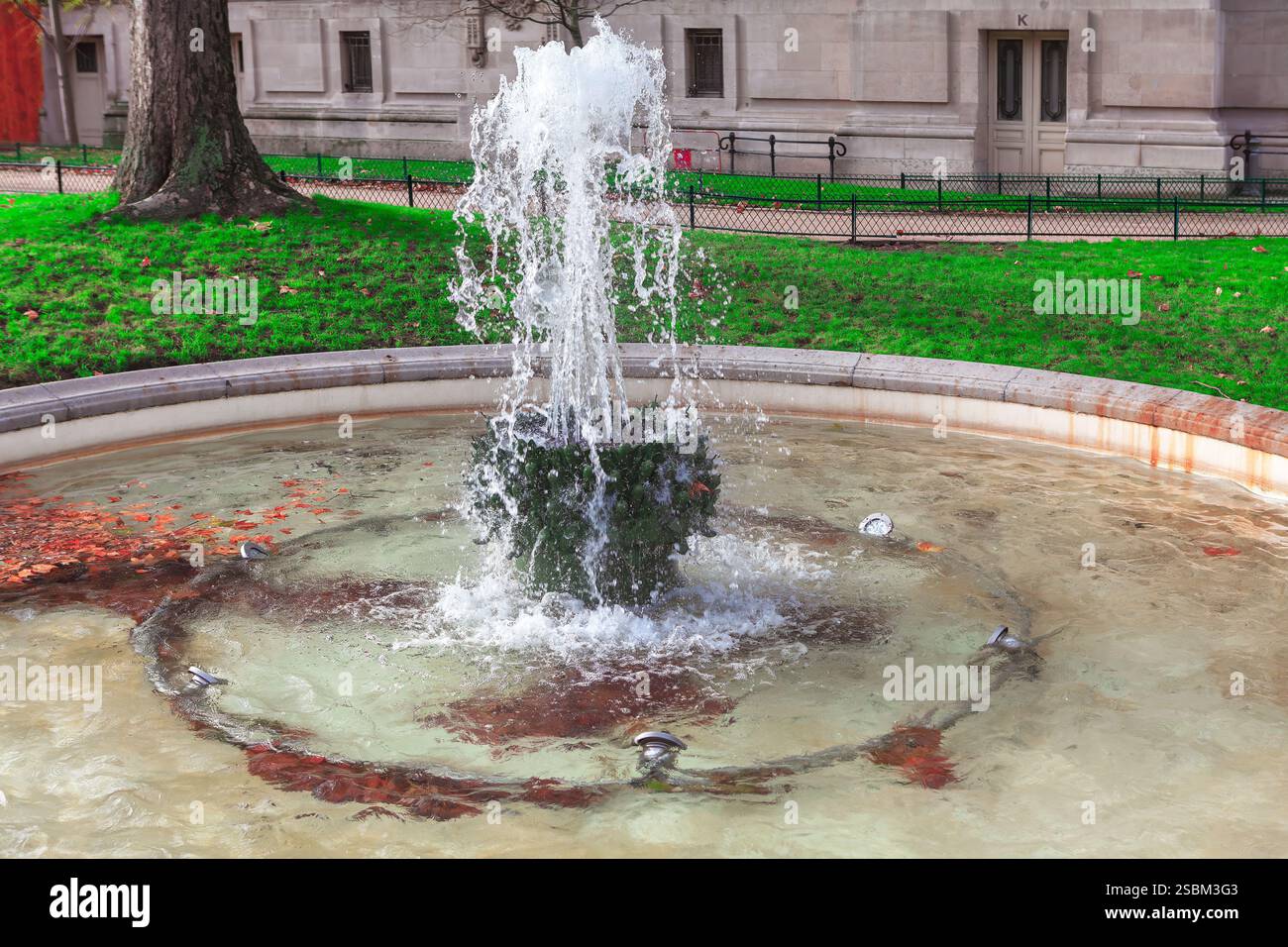 Small fountain in Paris features water gushing from a central stone ...