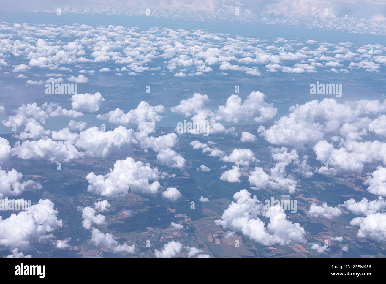 Bird's eye view of a landscape with a scattering of fluffy white clouds ...
