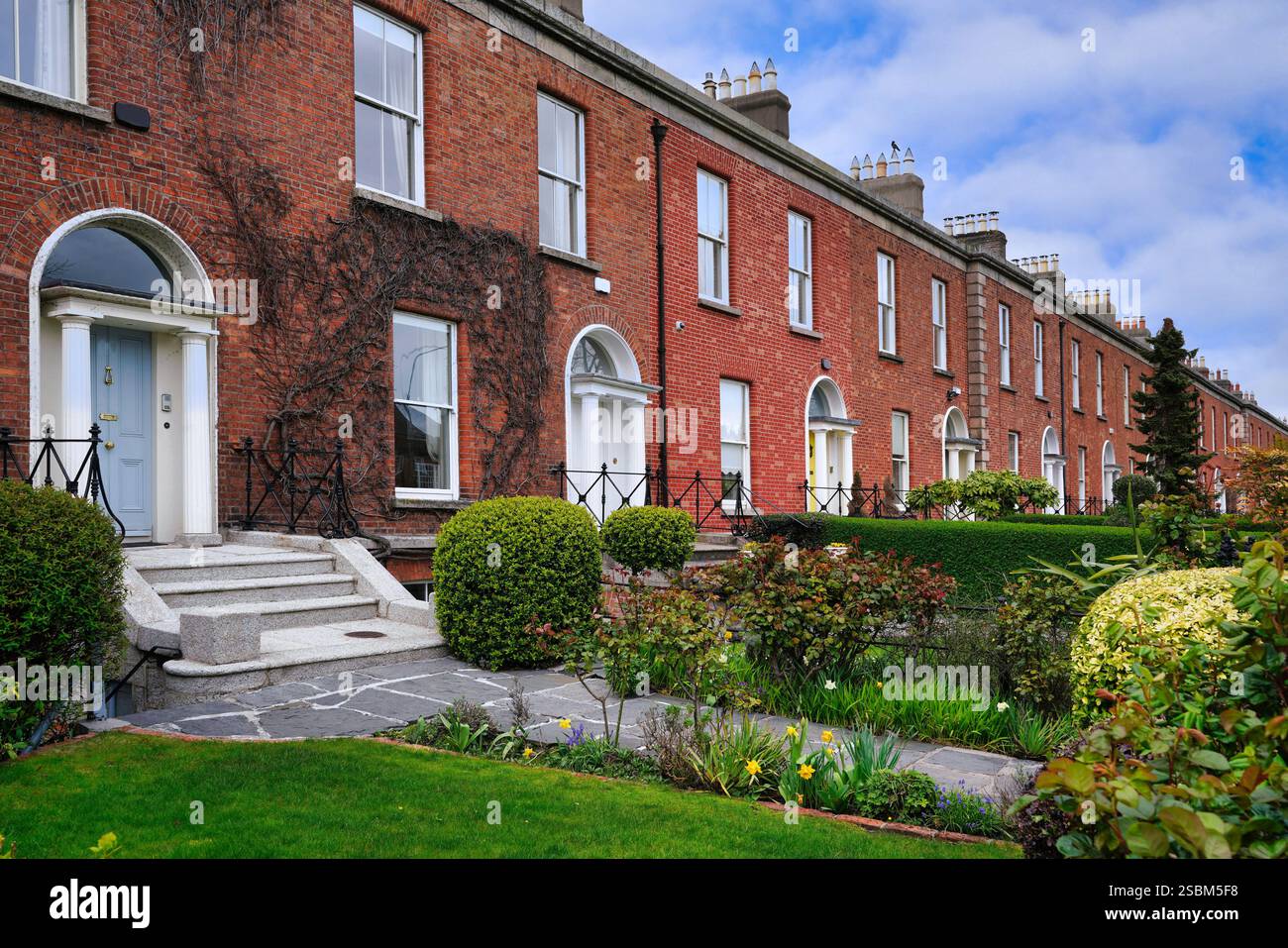 Row of brick townhouses with front gardens Stock Photo - Alamy
