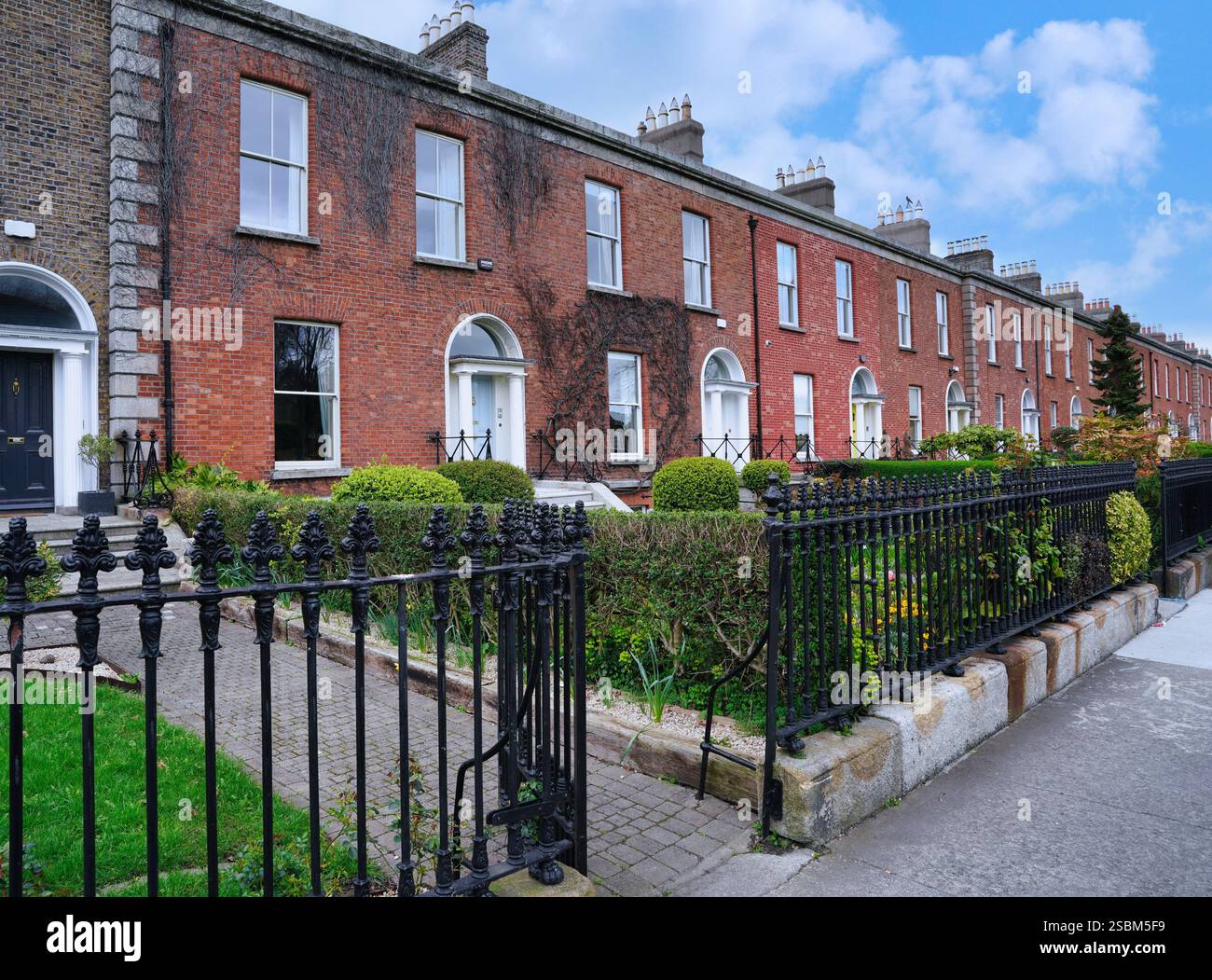 Row of brick townhouses with front gardens Stock Photo - Alamy