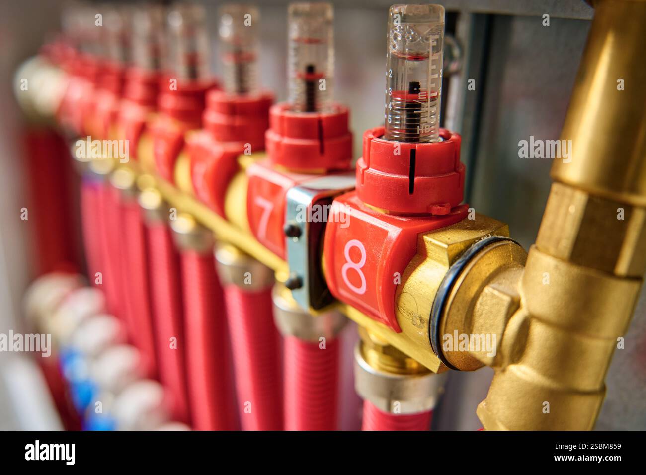 Close-up of an underfloor heating manifold with numbered flow meters ...