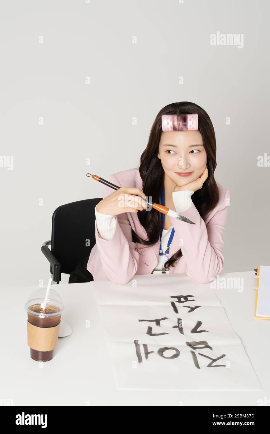 MZ employee sitting in front of a desk with a hair roller and doing ...