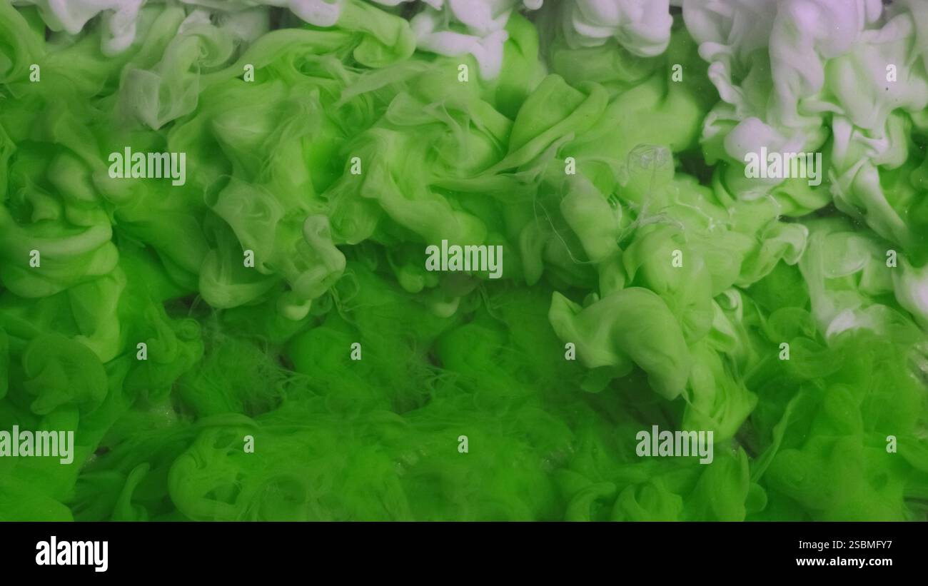 Liquid dye. Water ink surface. Defocused green white color haze cloud ...