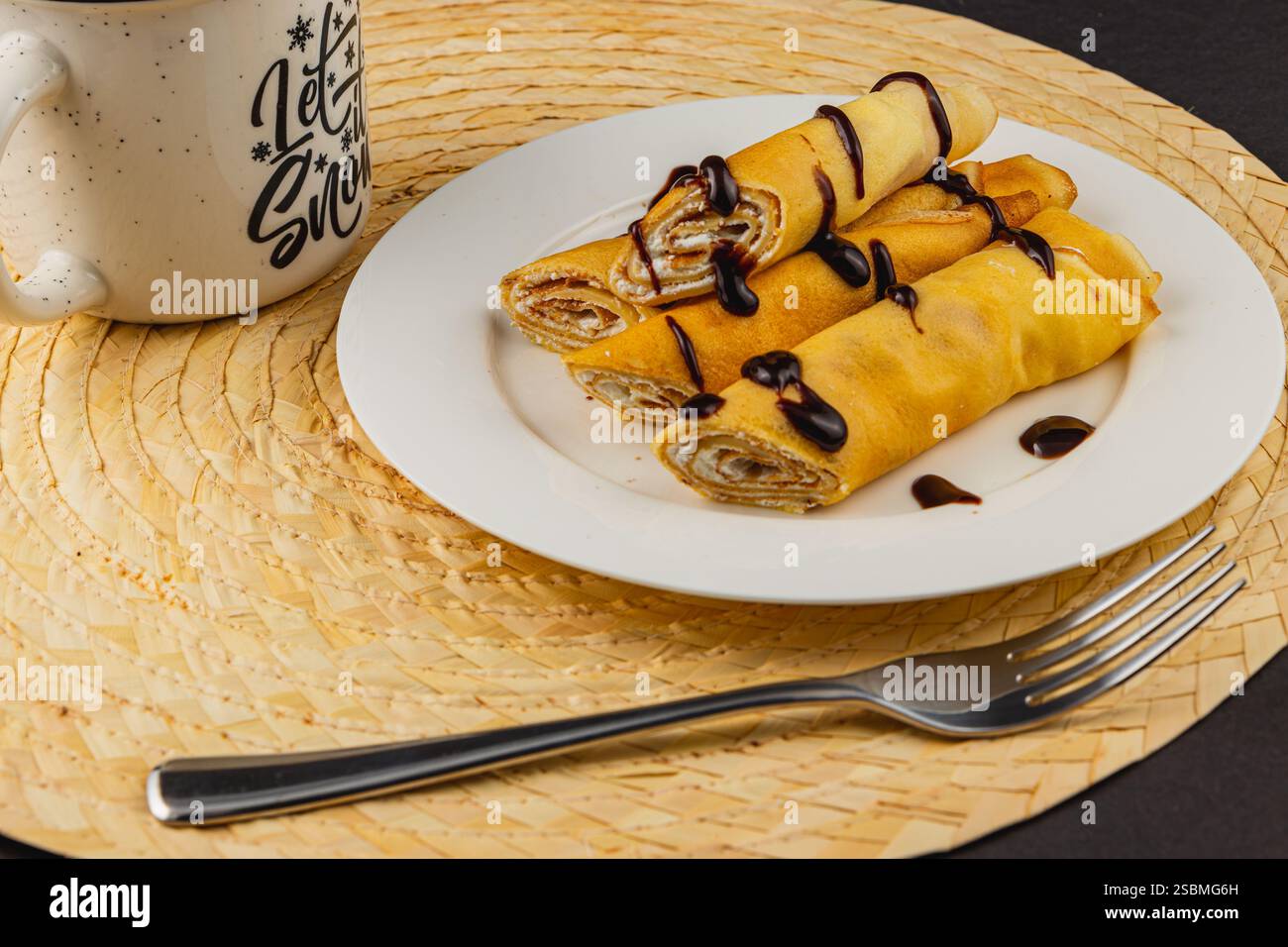 Warm, rolled crepes filled with sweet goodness sit elegantly on a white ...