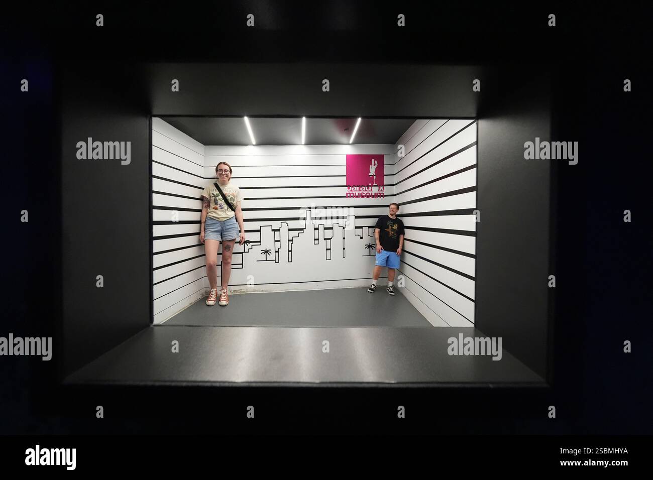 Visitors pose inside a proportion-distorting room at Paradox Museum ...