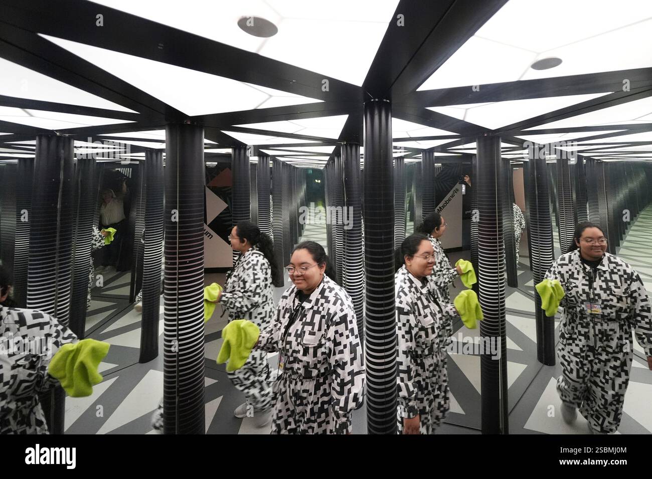 Paradox Museum Miami guide Maria Wong walks through a mirror maze as ...