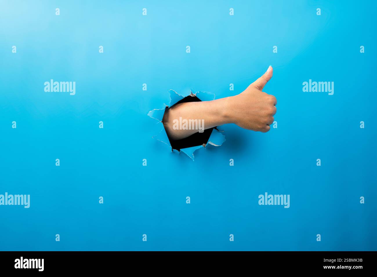 Human hand showing thumb up gesture from ripped paper. Hand sign ...