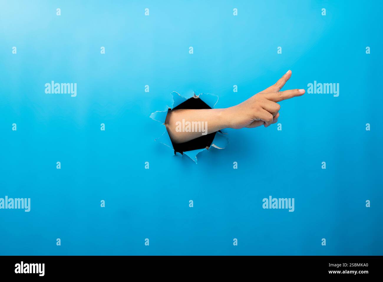 Human hand showing from ripped paper. Hand gestures of greeting or ...