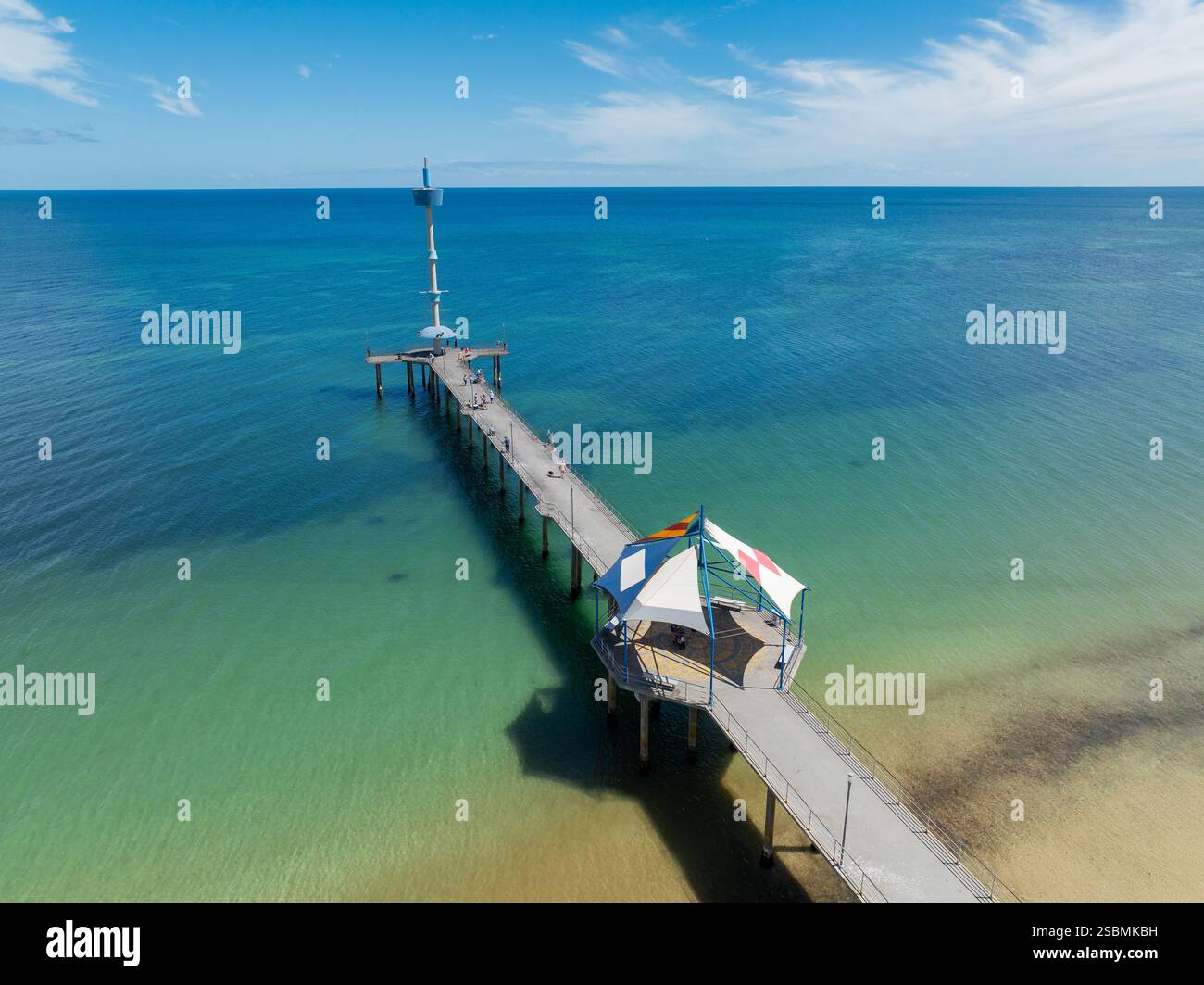 Aerial view of a beacon at the end of a long jetty over a calm sea At ...