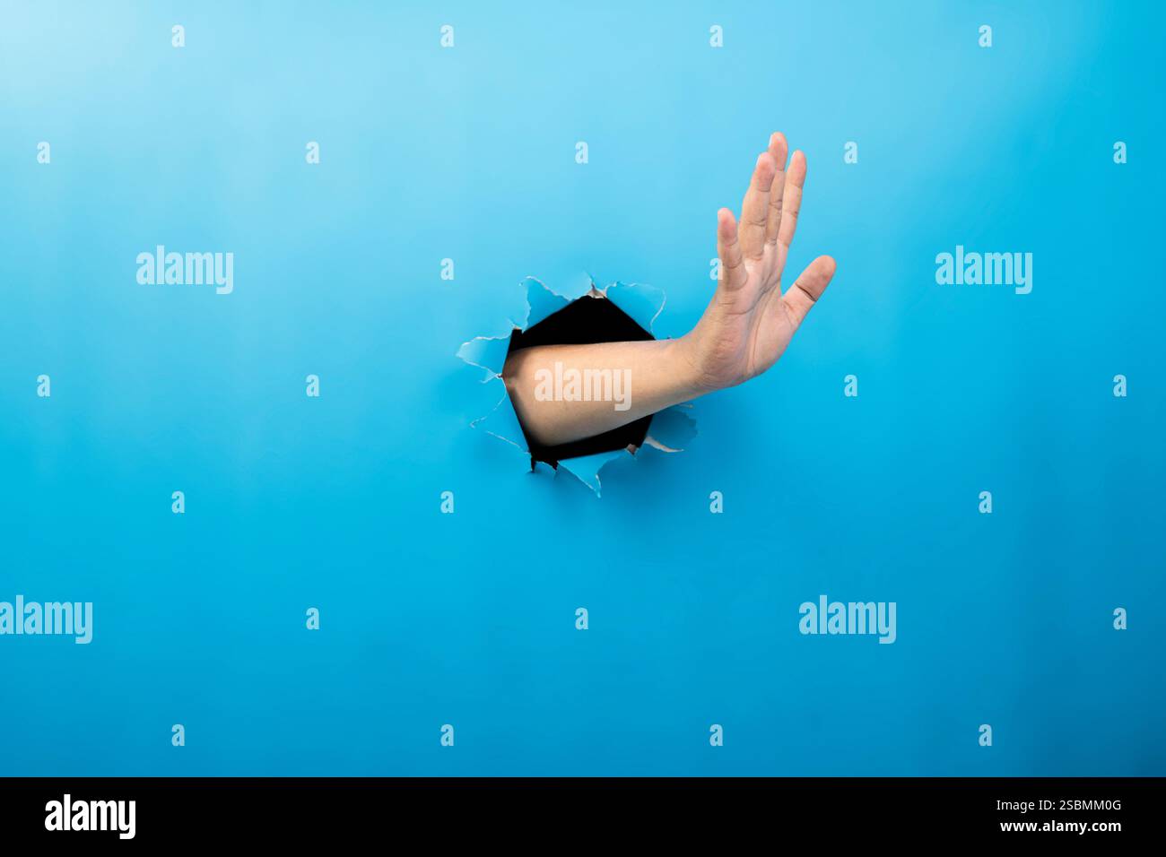 Human hand showing from ripped paper. Hand gestures of rejection or ...