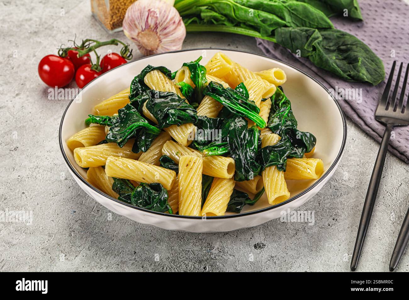 Italian cuisine - pasta tortiglioni with spinach Stock Photo - Alamy