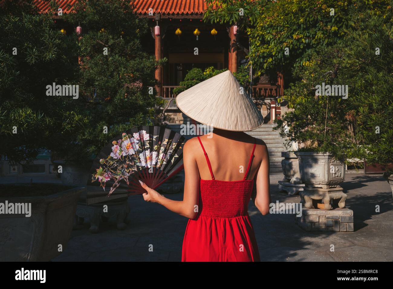 back of beautiful young woman tourist with fan in Non La hat in travel ...