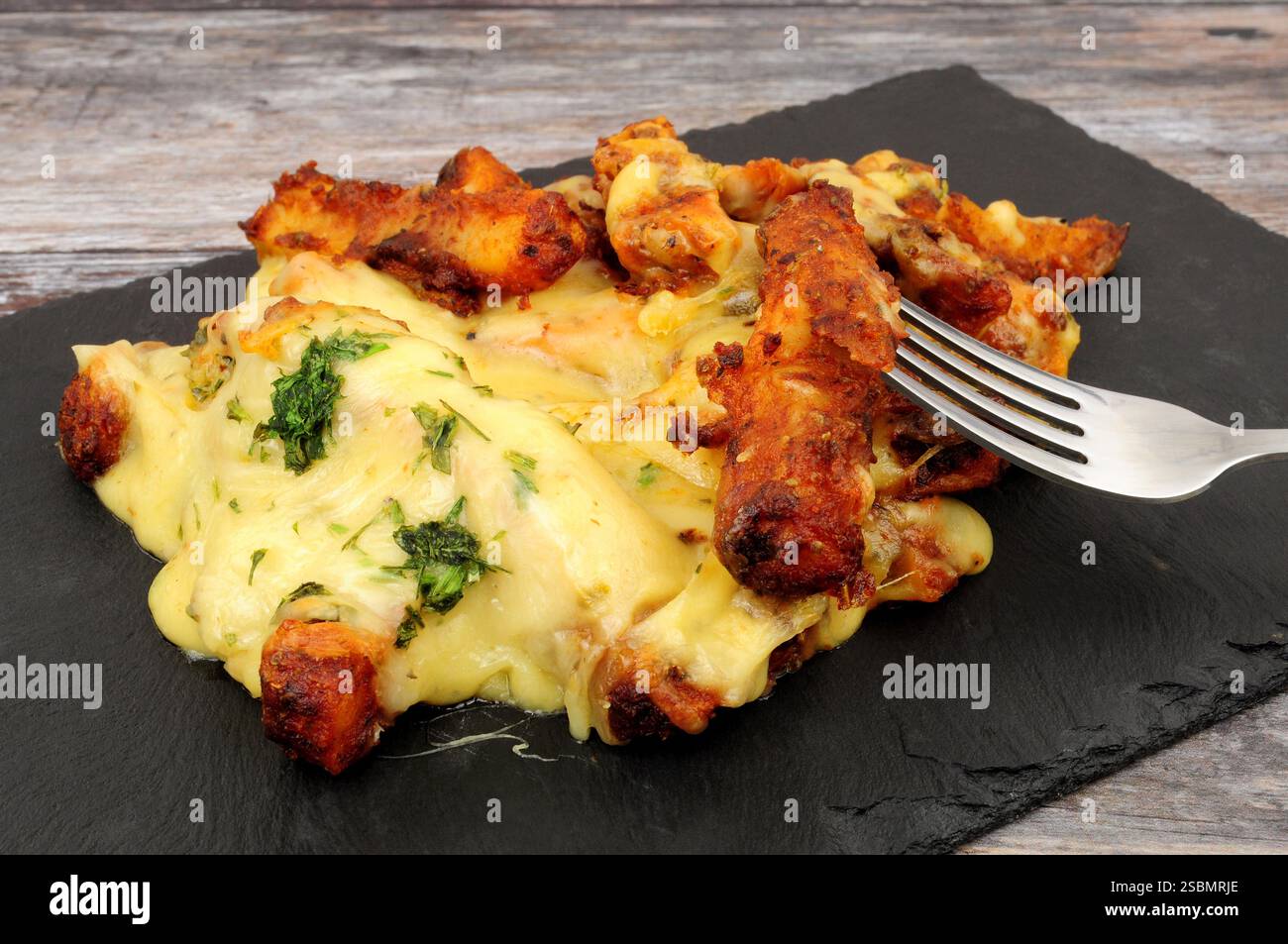 Portion of dirty cheesy fries on a slate serving board, fried battered ...