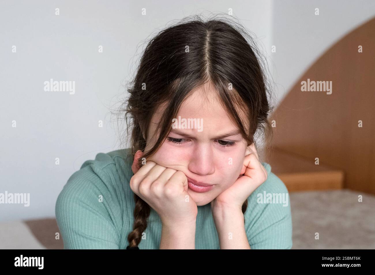 Portrait of sad little girl sitting on bed at home. Depressed kid with bad mood Stock Photo - Alamy