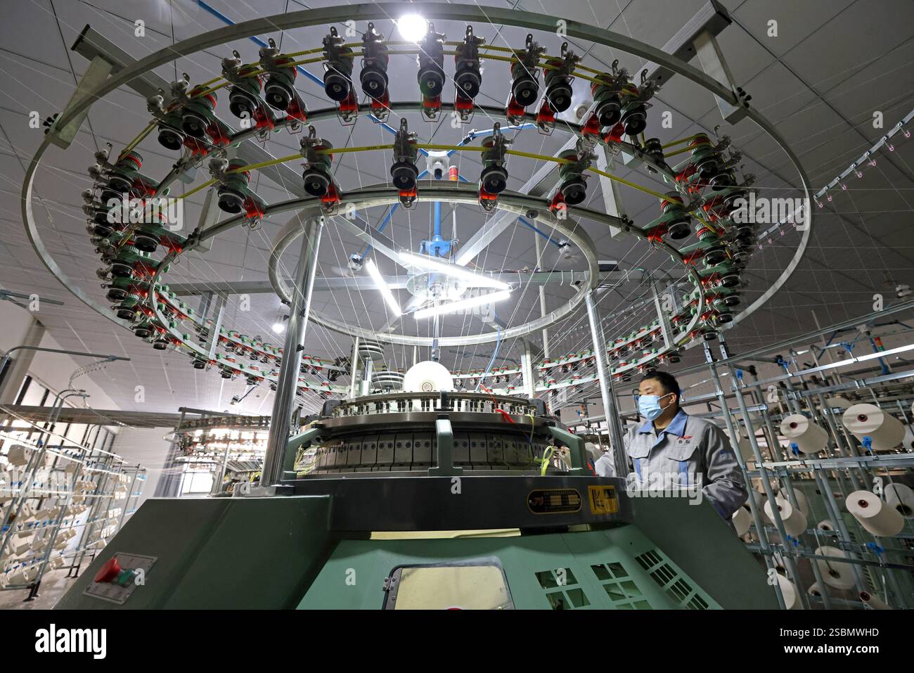 A worker of a textile company produces garment fabric products for export at a workshop in ...