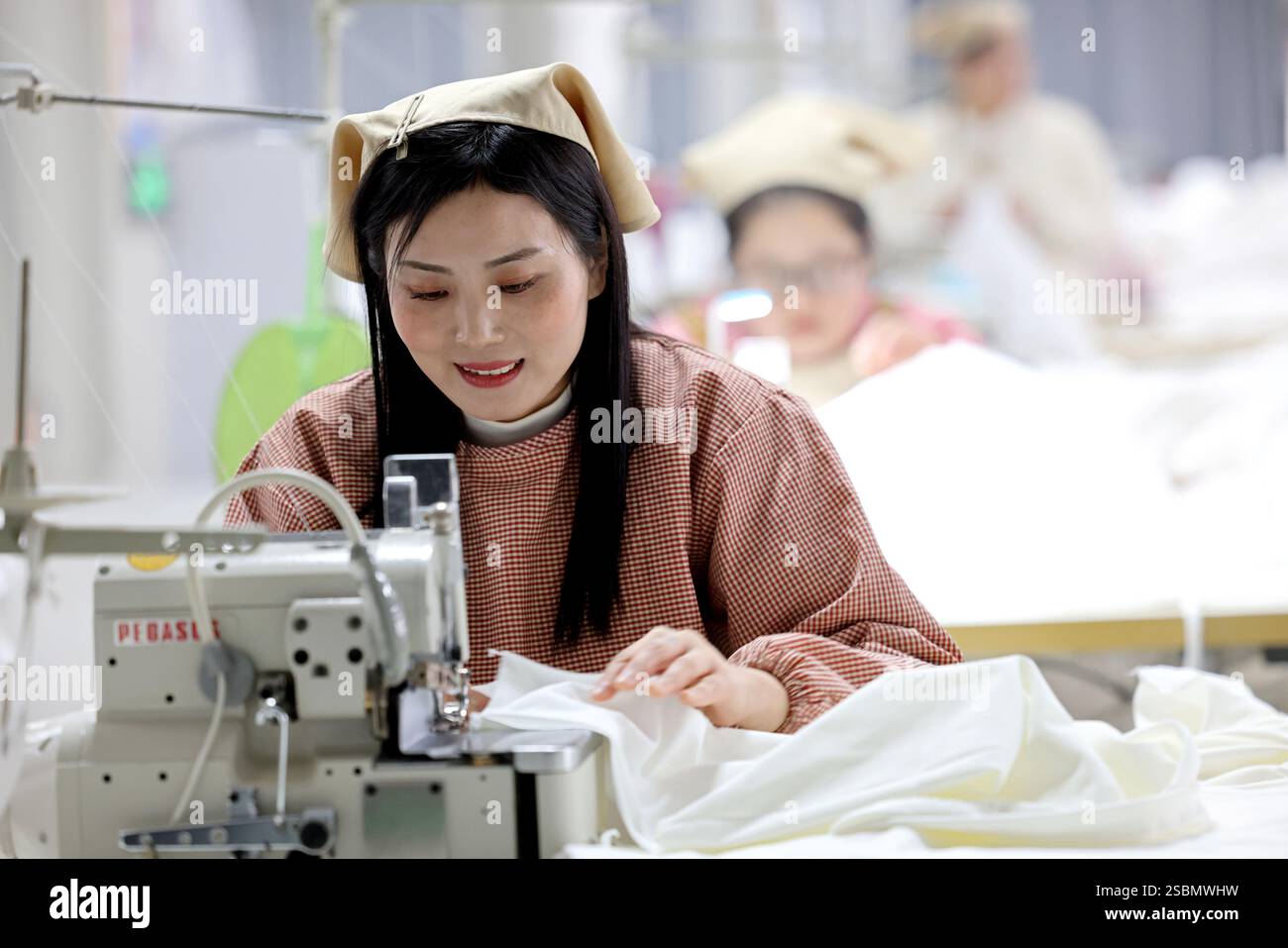 A worker of a textile company produces garments for export at a workshop in Zaozhuang, East ...
