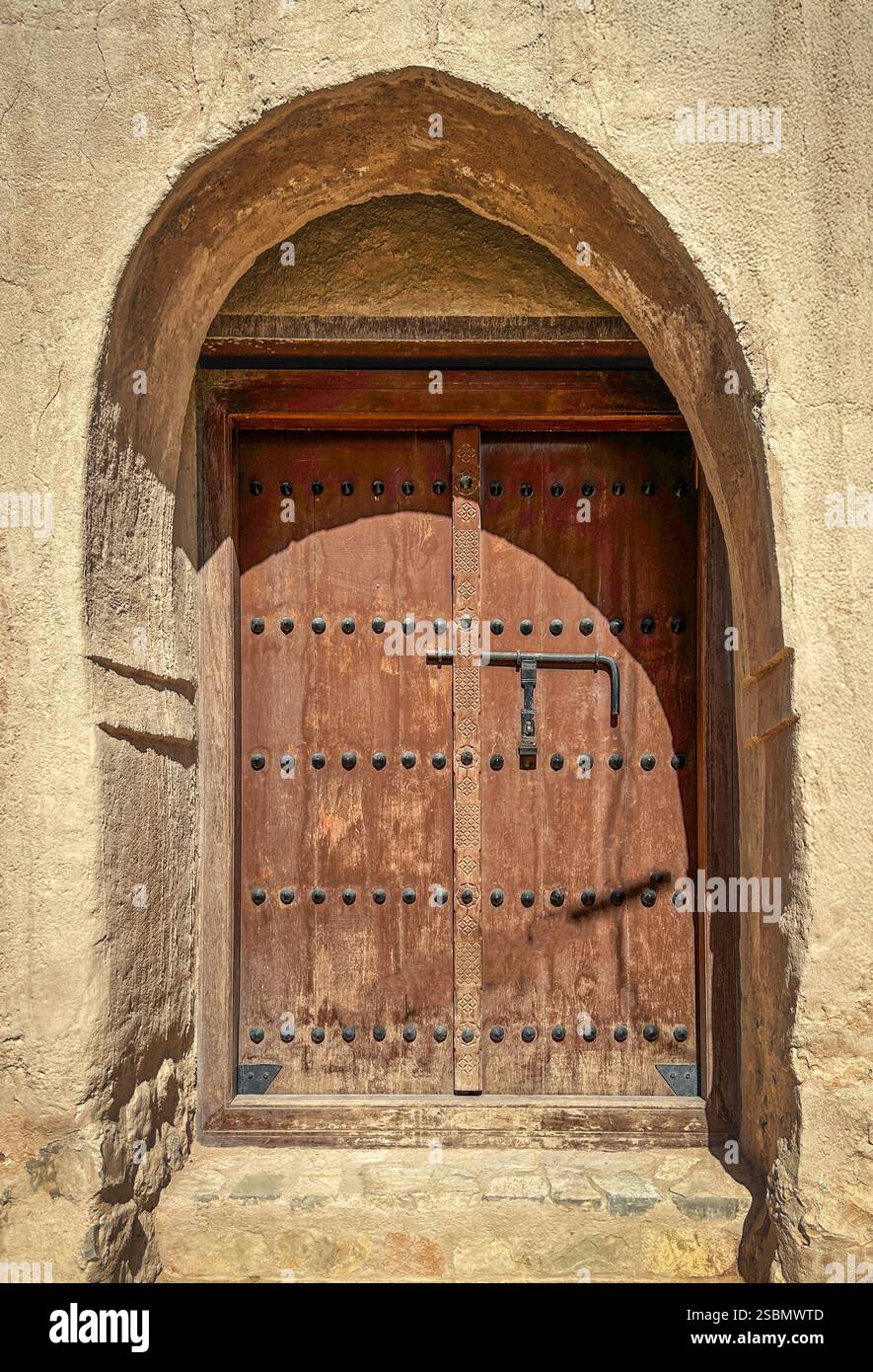 Adam, Oman - January 28 2025: A weathered wooden door set in a ...